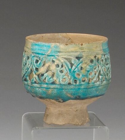 Bonhams : A Medieval Islamic pottery monochrome glazed openwork footed bowl