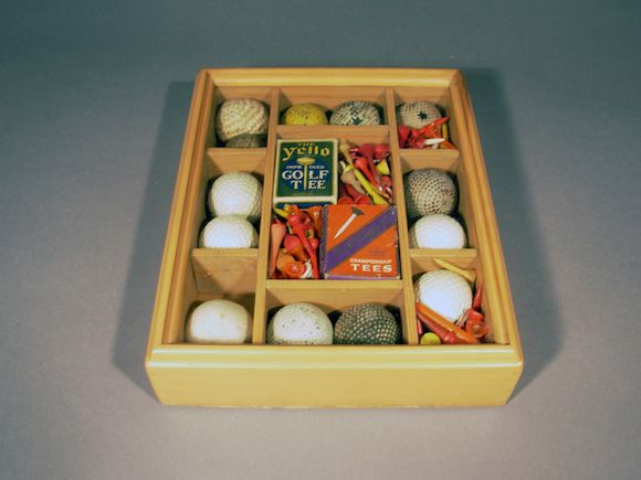 Bonhams : A shadow box display containing golf balls, tees, practice ...