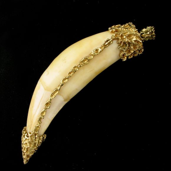 Bonhams : A gold capped animal tooth pendant