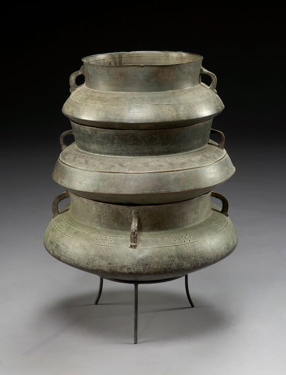 Bonhams : A set of three Asian bronze graduated vessels on stand