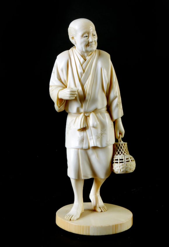 Bonhams : A Japanese carved ivory figure of a man holding a lantern