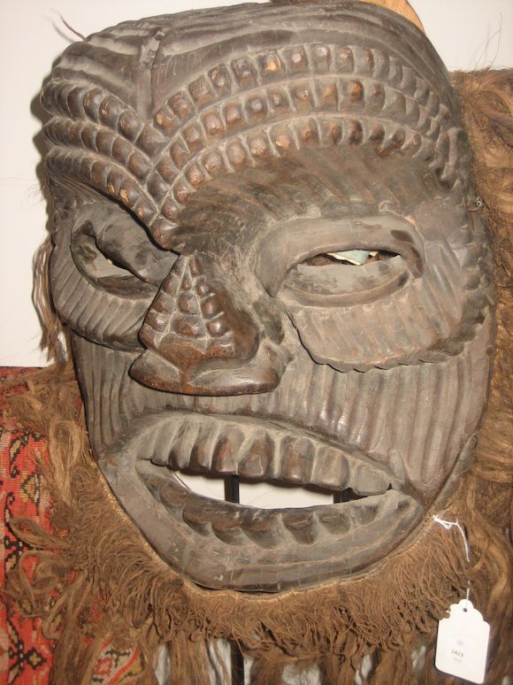 Bonhams : An African style carved wood and rafia face mask