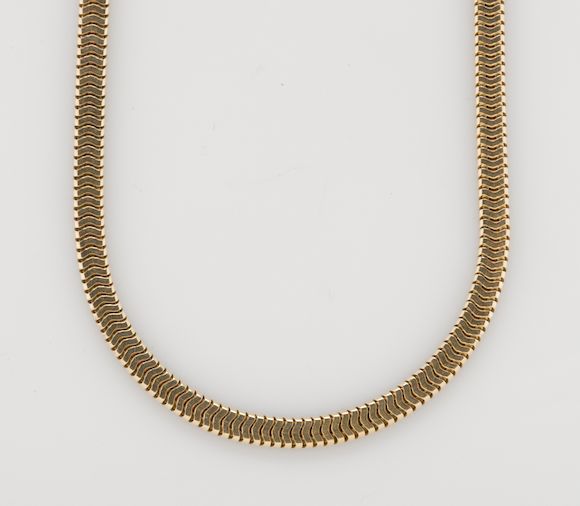 Bonhams : A 14k gold square snake chain suspending a charm