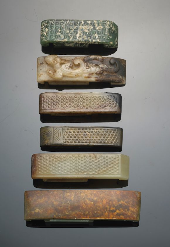 Bonhams : A group of six archaistic jade and hardstone scabbard slides