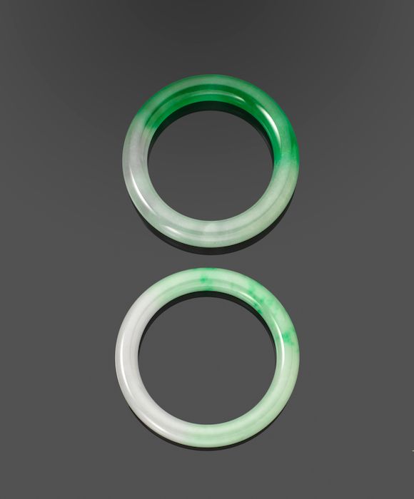 Bonhams : Two mottled green jadeite bangles
