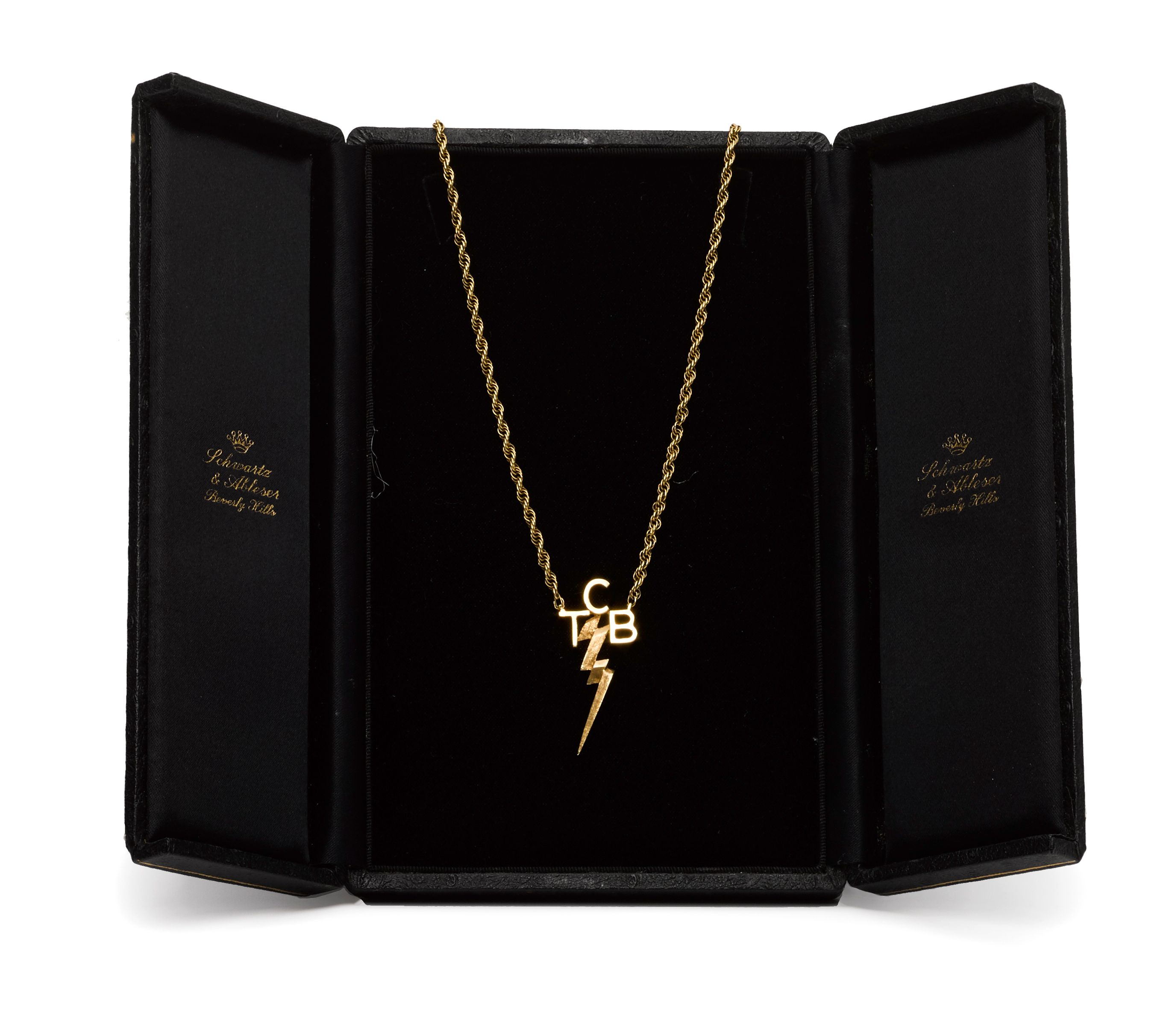 Bonhams : An Elvis Presley TCB gold necklace in original box