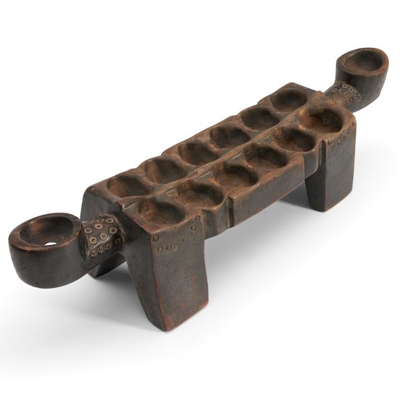 Bonhams Skinner : A Dan Mankala game board lg. 25 1/4, ht. 6 3/4, wd. 5 ...