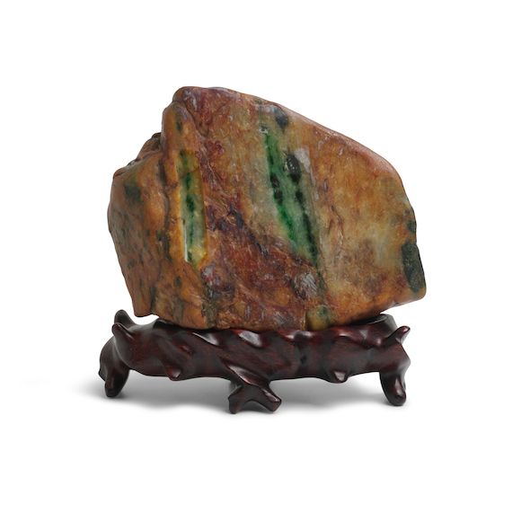 Bonhams : A RARE RUSSET-SKINNED JADEITE BOULDER (wood stand)